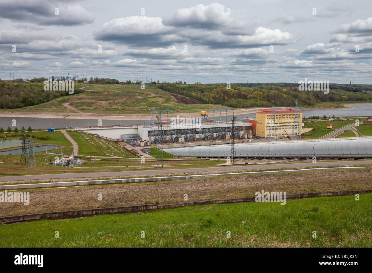 hydro power plant pipes, machine rooms and ponds on landscape with grey ...