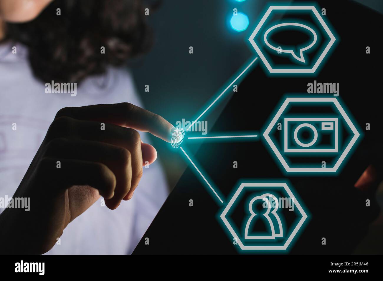 An unrecognizable girl going to touch digital tablet screen in a dark ...