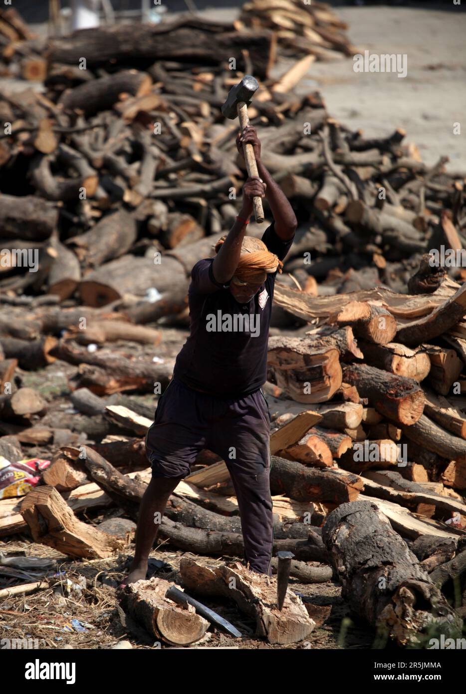 Prayagraj, India. 04th June, 2023. An Indian labourer chops wood log ...