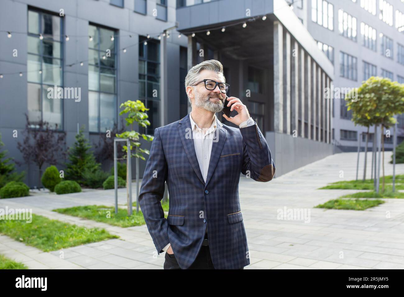 Successful mature gray-haired man talking on the phone, senior ...
