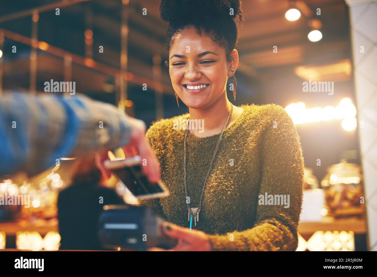 Settle your bill the effortless way. a waitress accepting a NFC payment ...