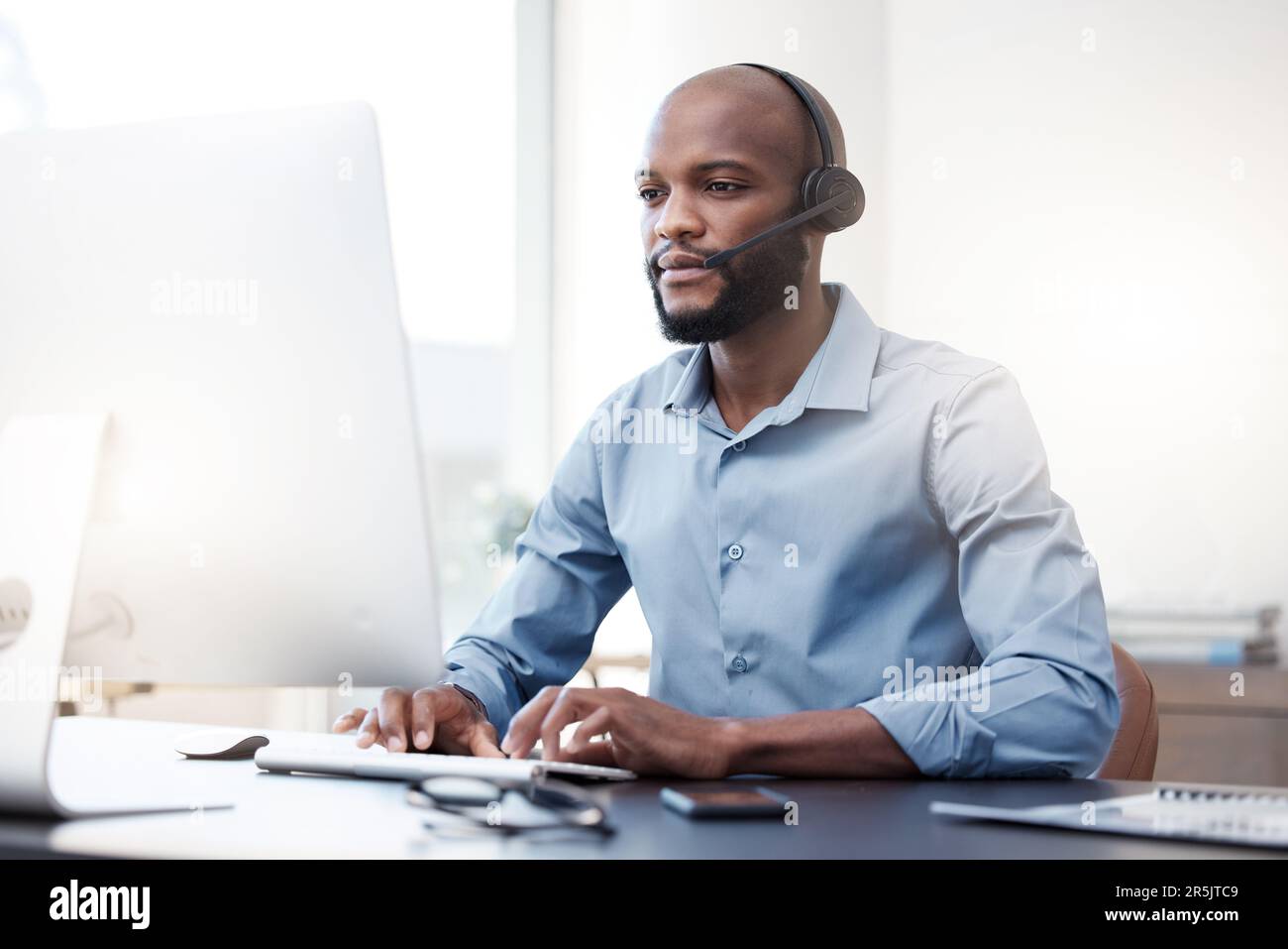 Black man typing at computer, call center and contact us, communication ...