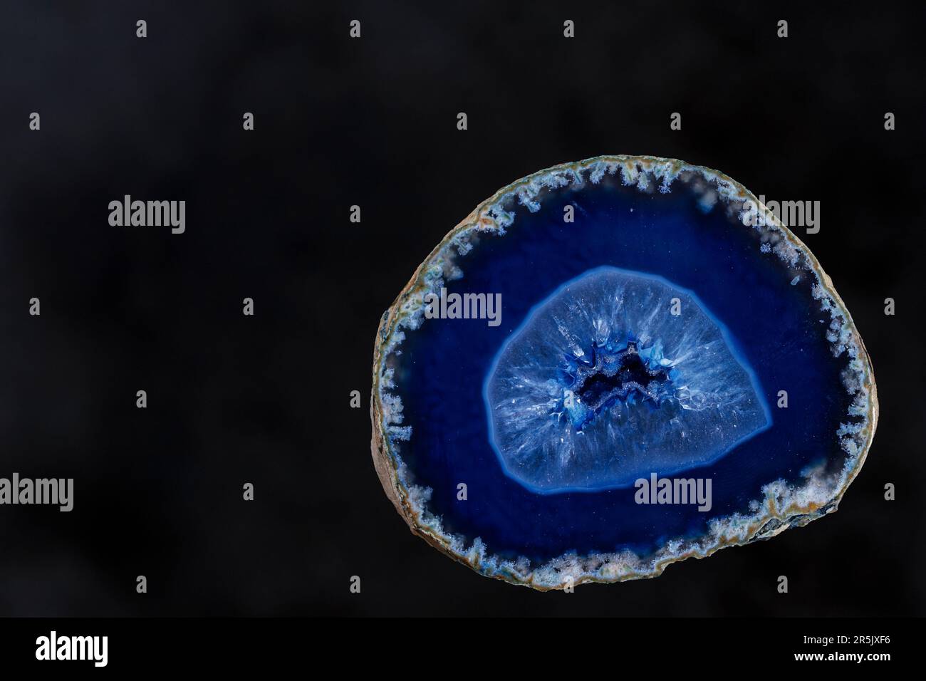 A blue agate with a black shaded background. In the center of the ...