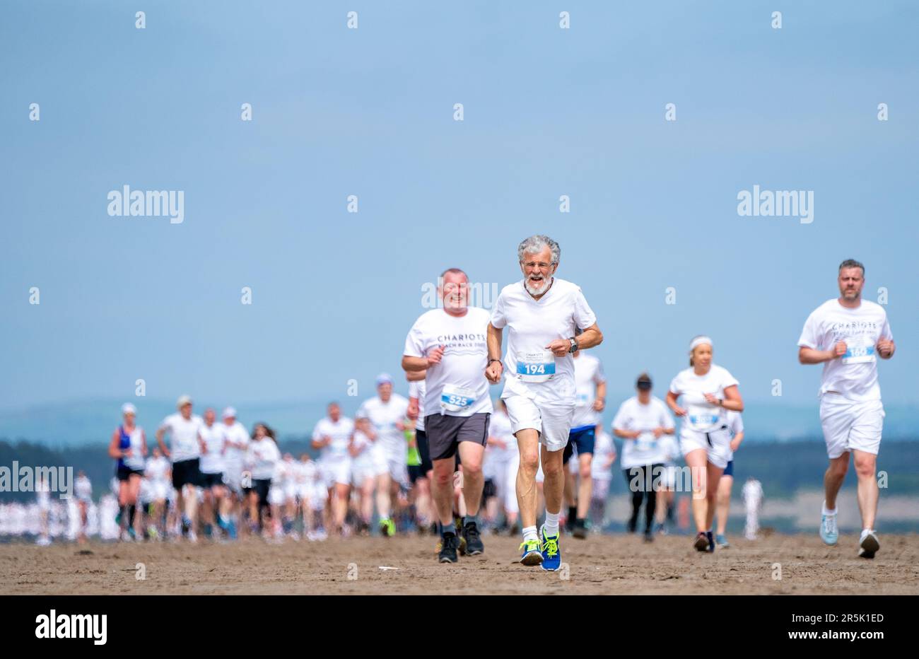 Runners, wearing white, compete in the annual Chariots of Fire race ...