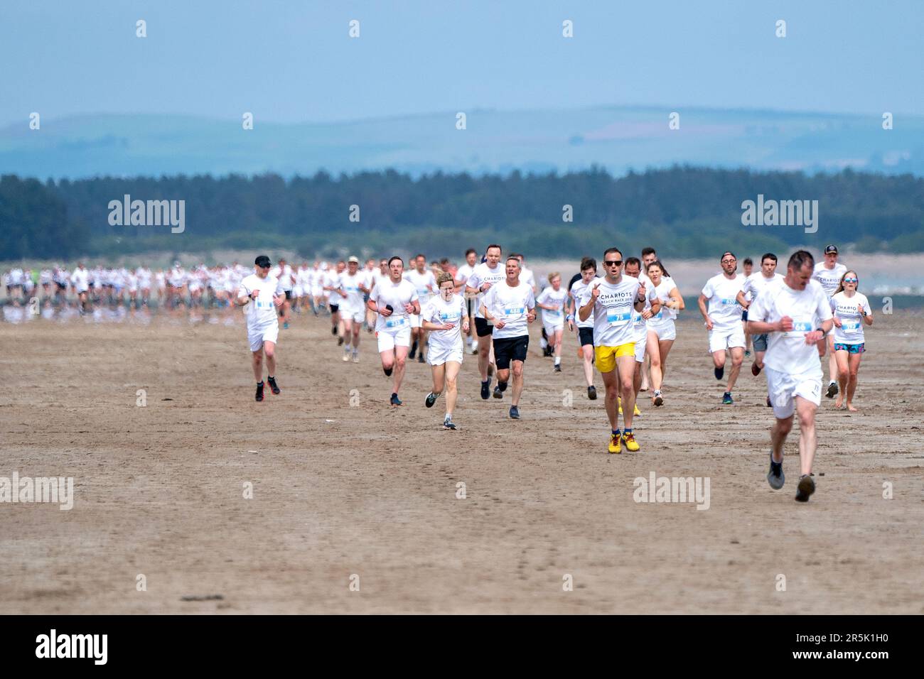 Runners, wearing white, compete in the annual Chariots of Fire race ...