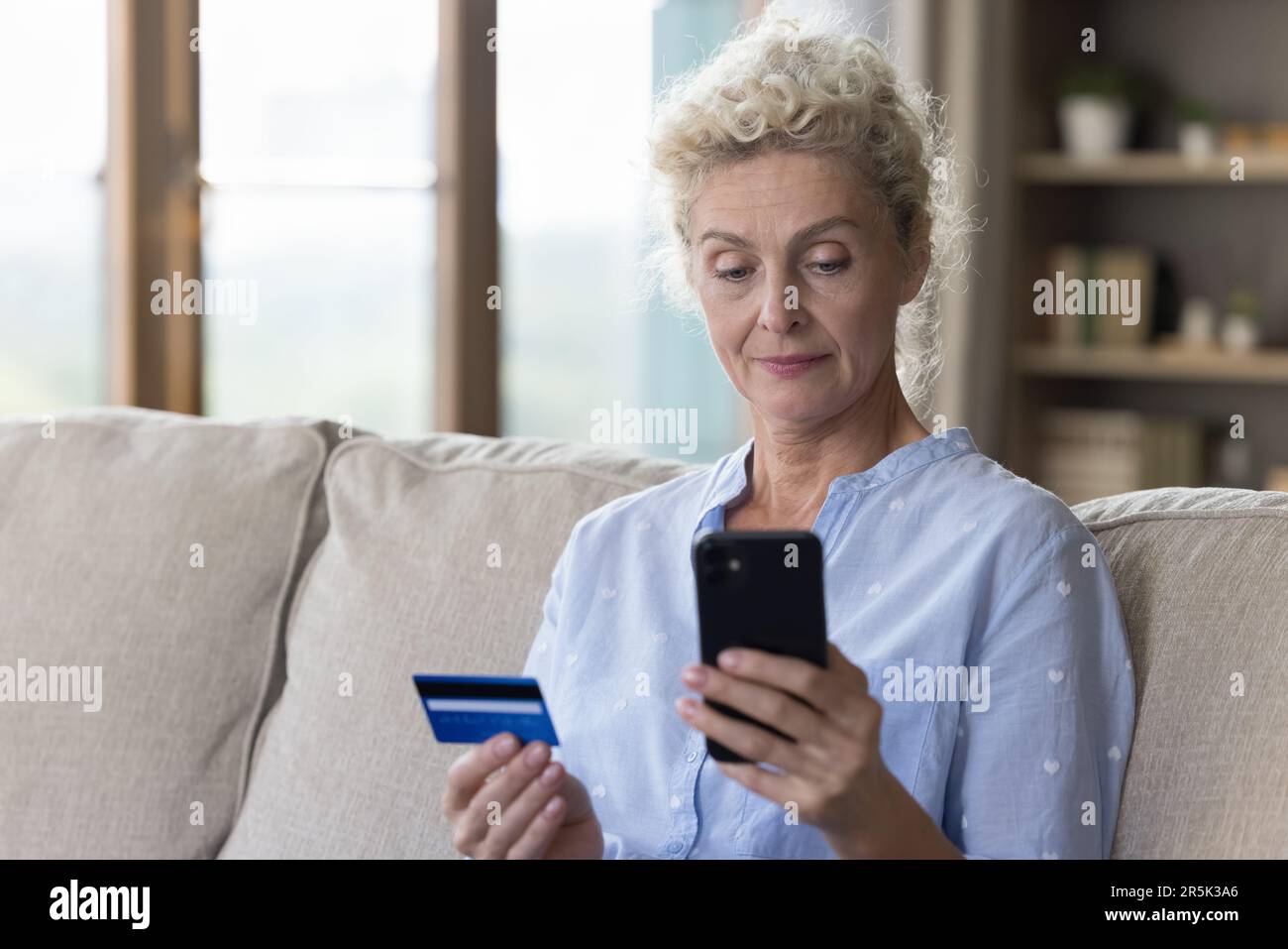 Serious mature bank client woman making online payment Stock Photo - Alamy