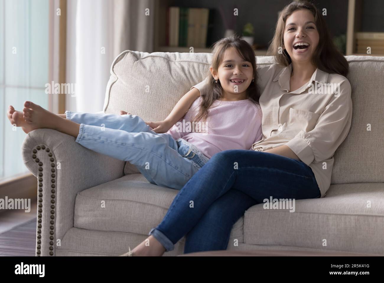 Happy mom and child girl resting on comfortable sofa together Stock ...