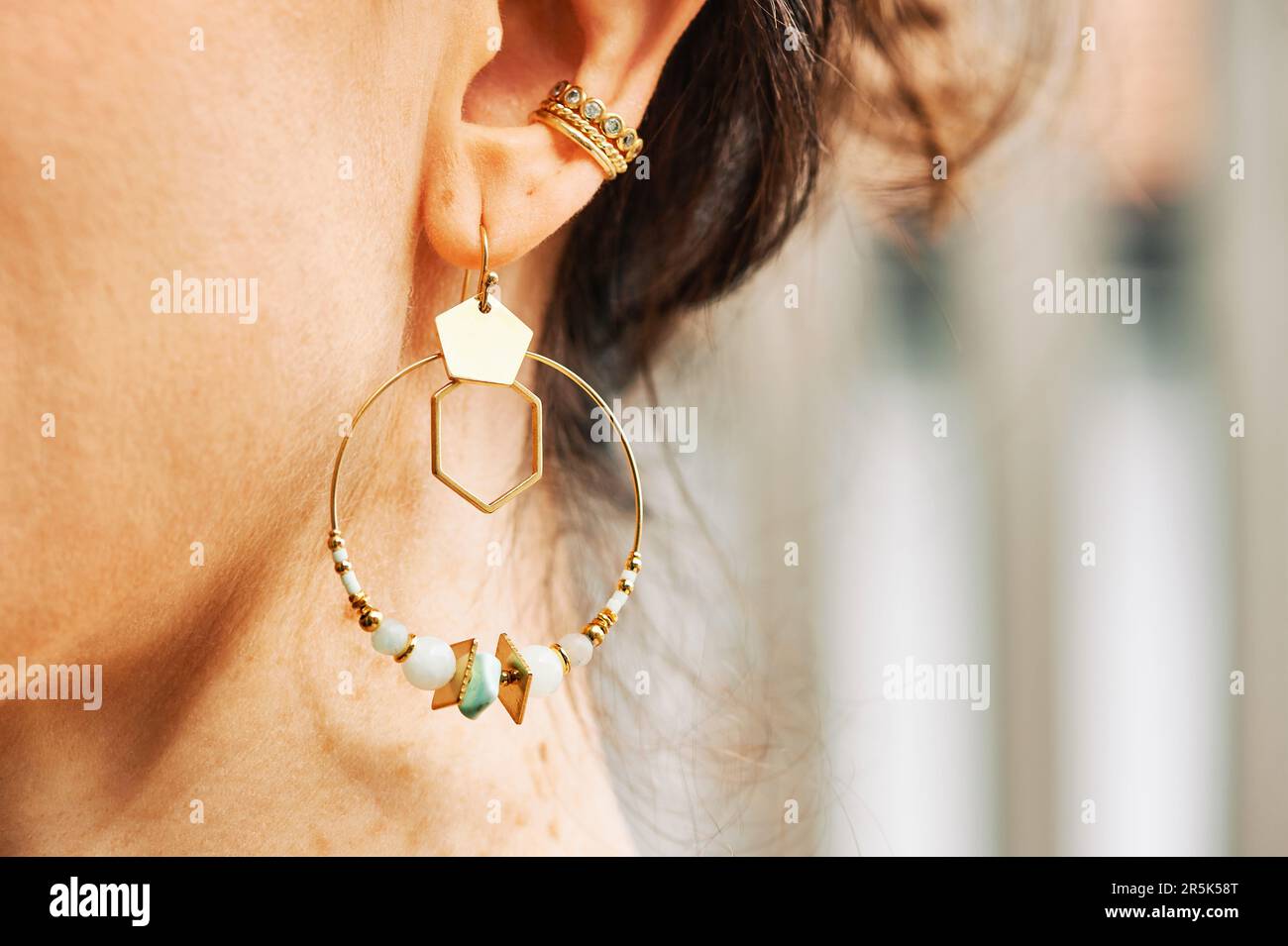 Close up image of female ear wearing modern earring Stock Photo - Alamy