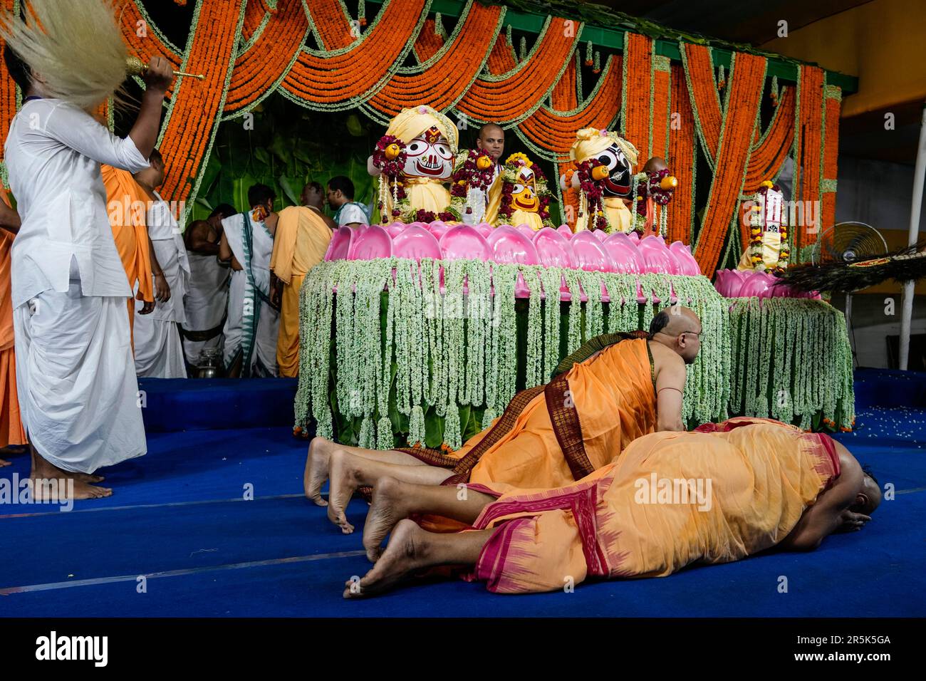 Hindu priests pray in prostration in front of the idols of Hindu ...
