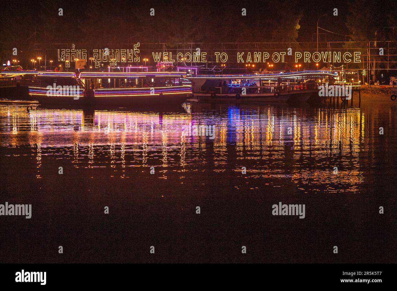 Dinner cruise boats on the Praek Tuek Chhu River at night. Bilingual ...