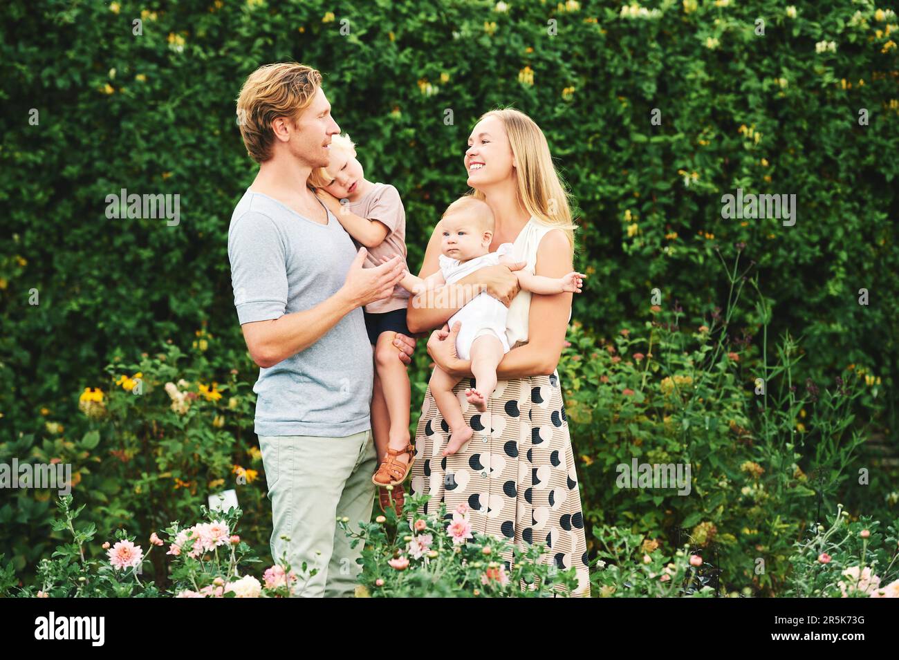 Happy young family with small children posing in summer garden, loving ...