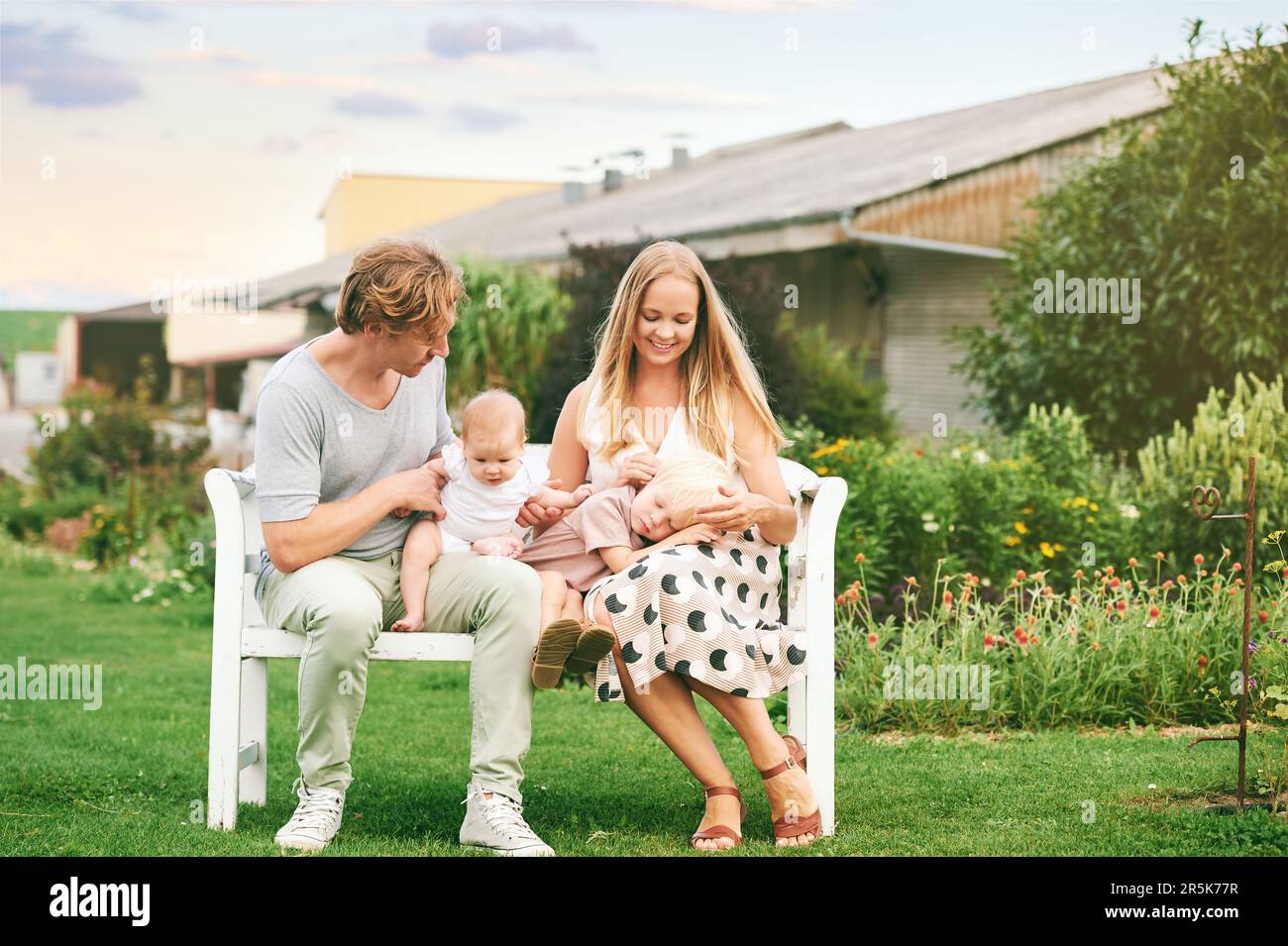 Outdoor portrait of happy young family with children, baby girl and ...