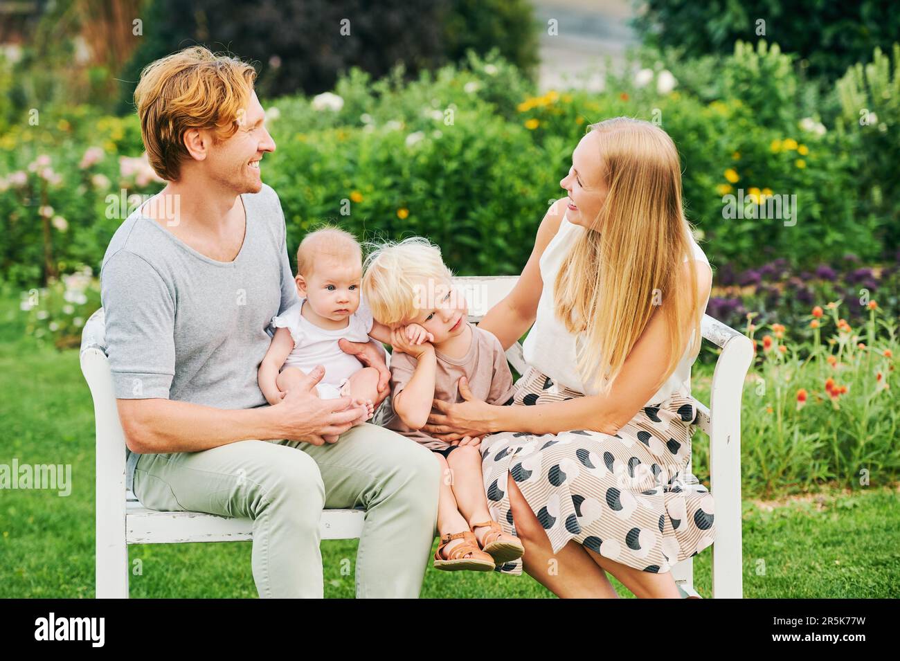 Outdoor portrait of happy young family with children, baby girl and ...