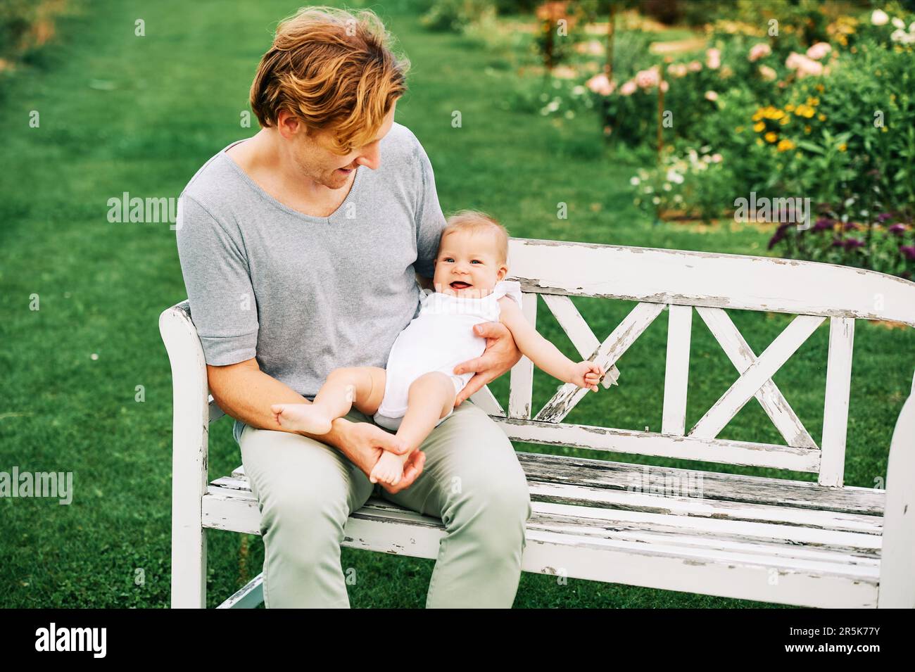 Happy young father relaxing in park with adorable baby, dad sitting on ...