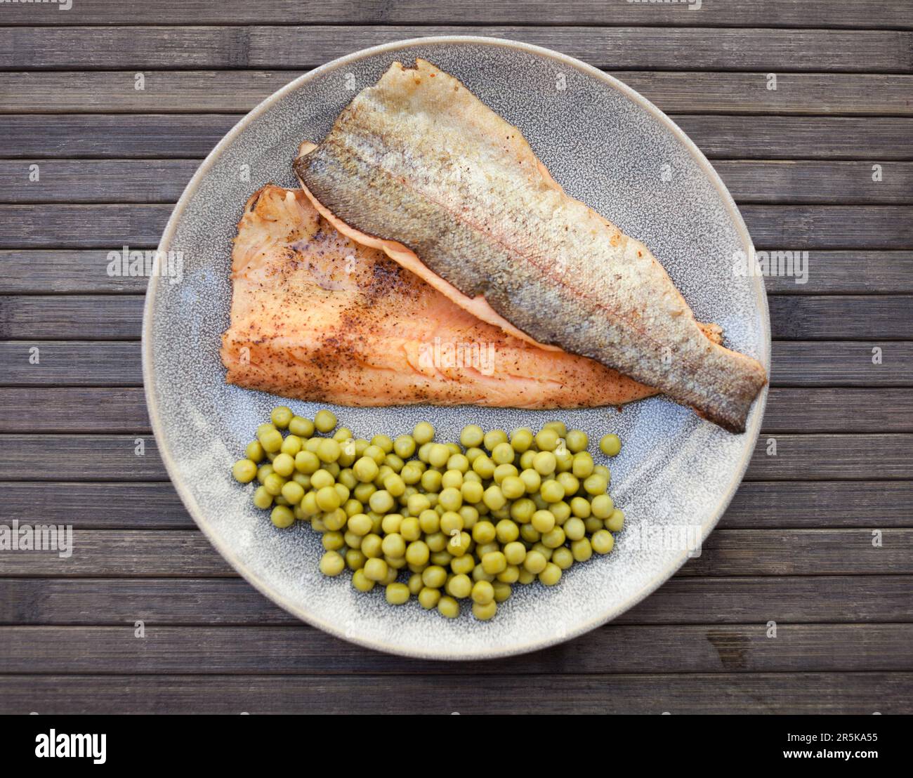 Fried trout fillets served with green peas Stock Photo - Alamy