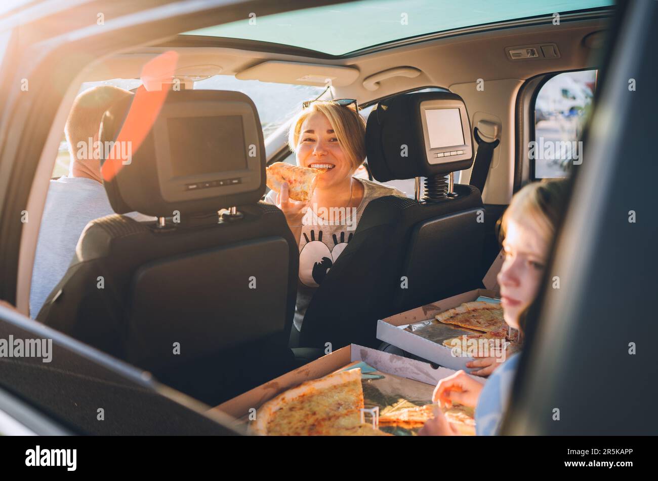 Portrait of young woman eating just cooked Italian pizza while she ...