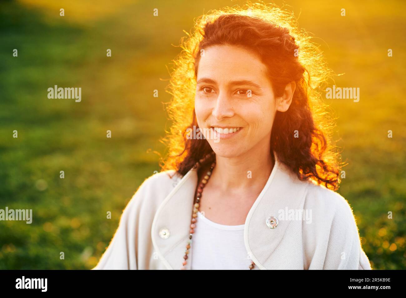 Sunset close up portrait of beautiful mature woman with curly hair ...