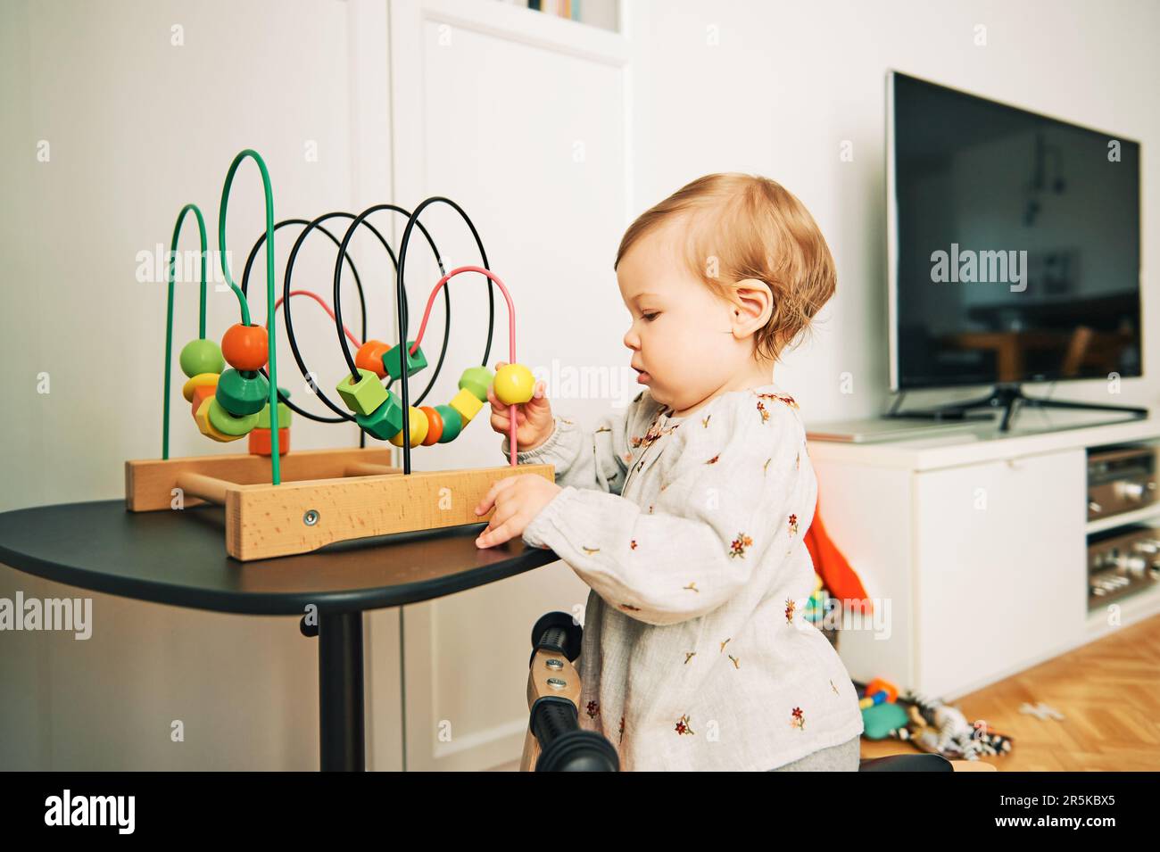 Cute toddler girl playing maze toy, concentrated baby developing fine ...