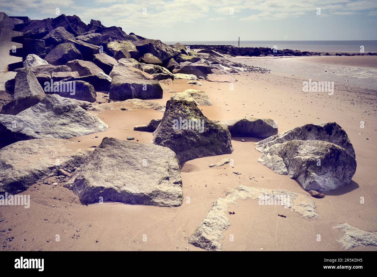 Rocks scattered on beach Stock Photo - Alamy