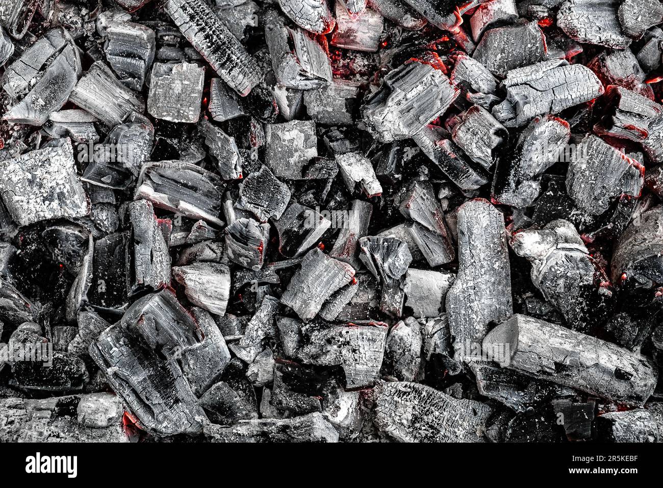 The texture of burning firewood and charcoal with the remnants of the ...