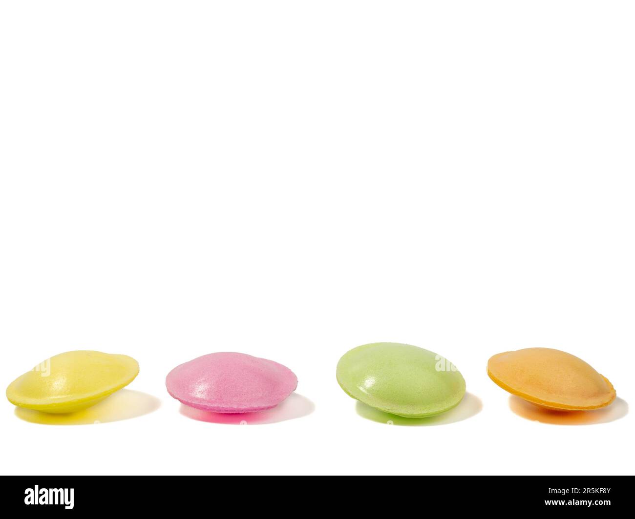 Sweet candies in the shape of a UFO in different colors on a white ...