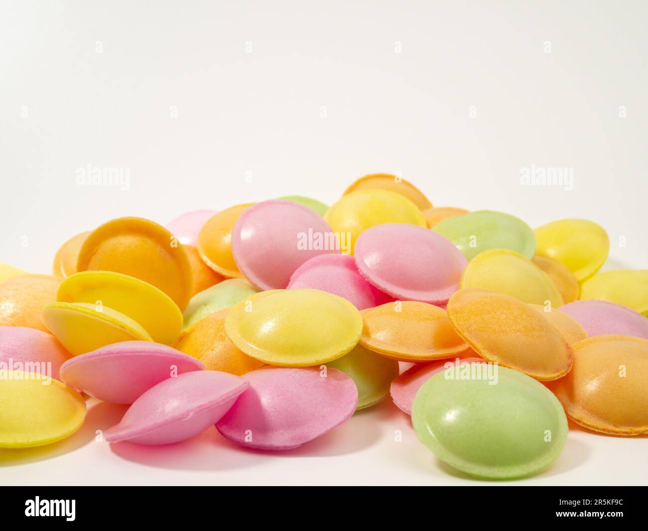 Sweet candies in the shape of a UFO in different colors on a white ...