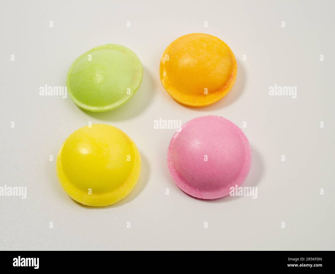 Sweet candies in the shape of a UFO in different colors on a white ...