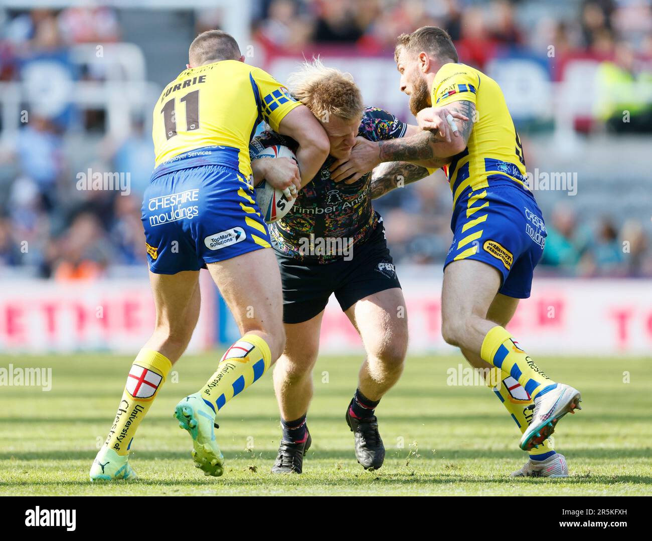 Hull FC’s Brad Fash is tackled by Warrington Wolves’ Ben Currie (left ...