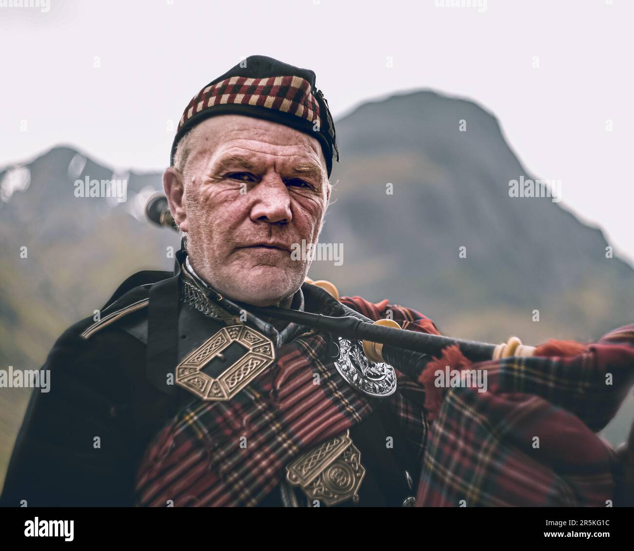 A Scottish piper stands tall, donning traditional attire, capturing the ...