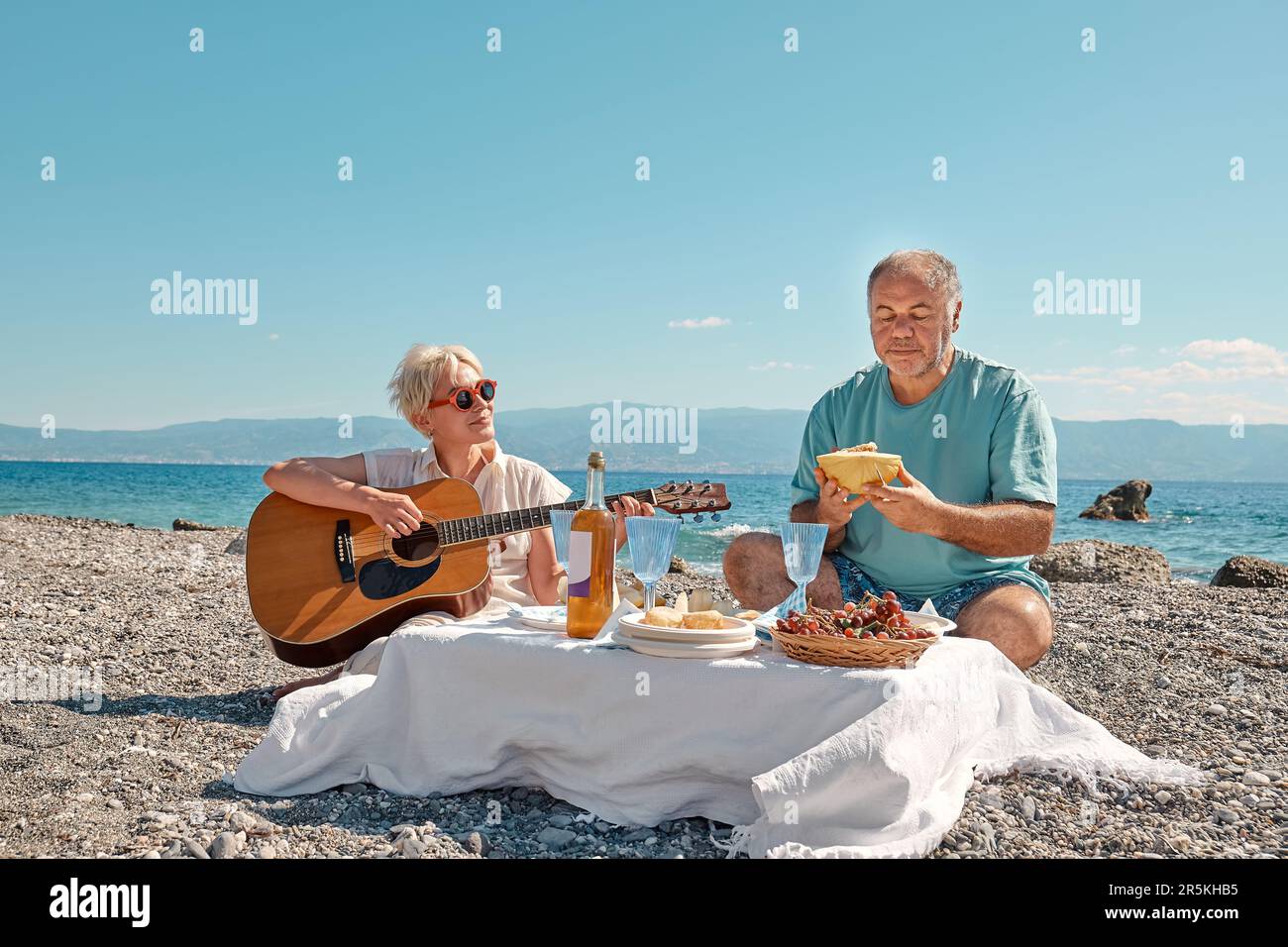 Summer beach picnic. Middle aged couple having picnic at the beach ...