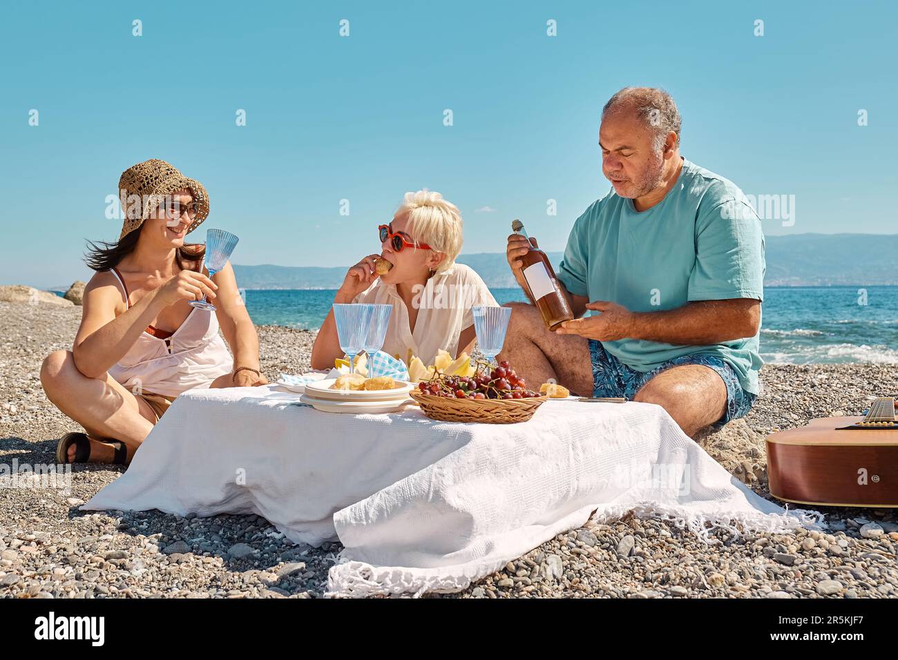 Summer beach picnic. Group of friends having picnic with fresh fruit ...