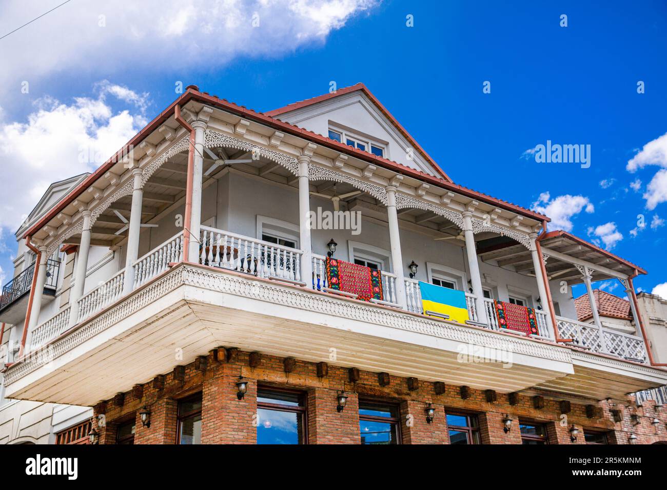 Traditional carved balcony and ukrainian flag in the centre of old ...