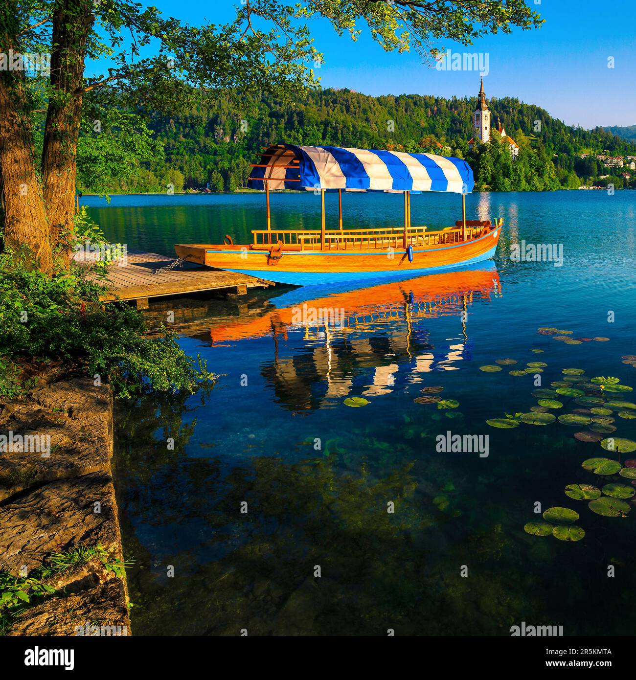 Pletna boat anchored at the pier on the lake. Pletna rowing boat and ...