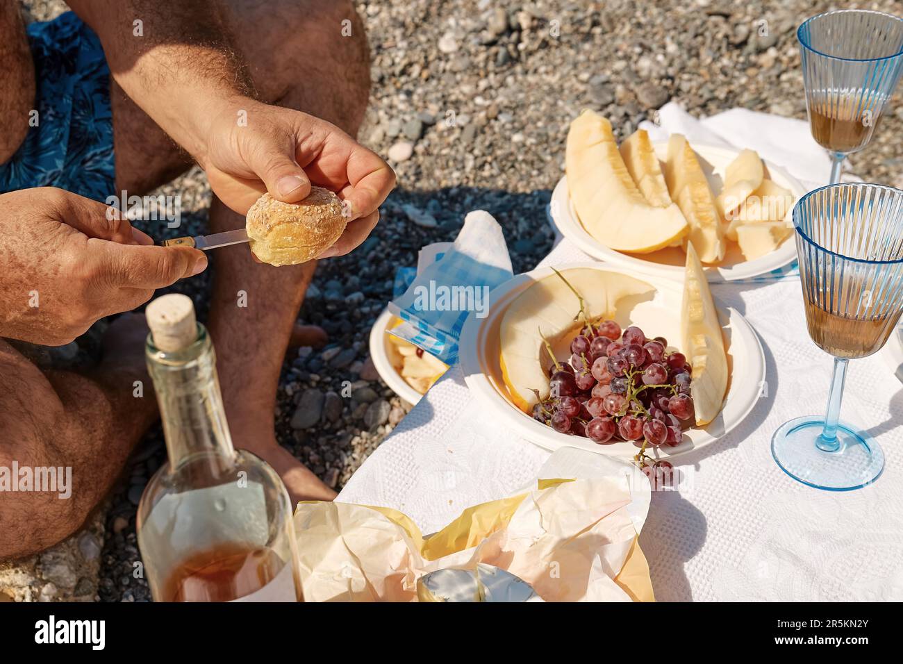 Summer beach picnic. Hands of man preparing appetizers for picnic with ...