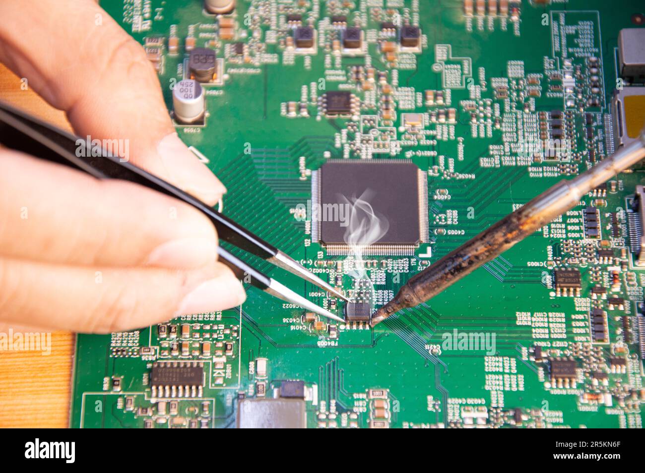 top view, mechanic repairing motherboard, soldering Stock Photo - Alamy