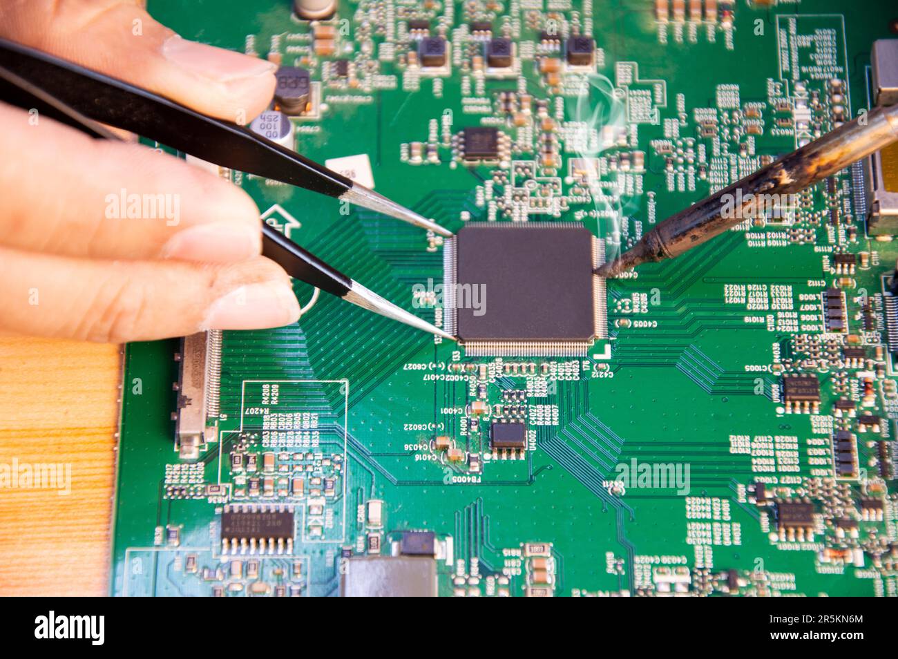 top view, mechanic repairing motherboard, soldering Stock Photo - Alamy