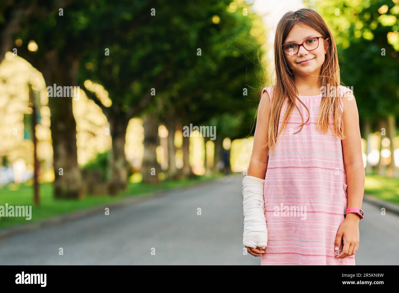 Outdoor portrait of sweet little girl with a cast Stock Photo - Alamy