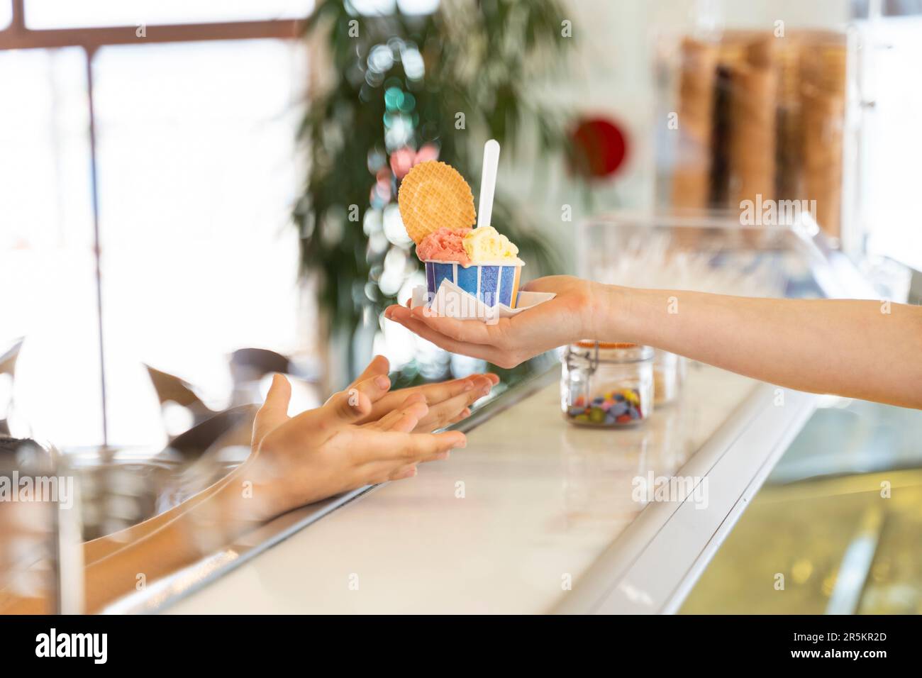 Woman serving a tub of ice cream to some children Stock Photo - Alamy