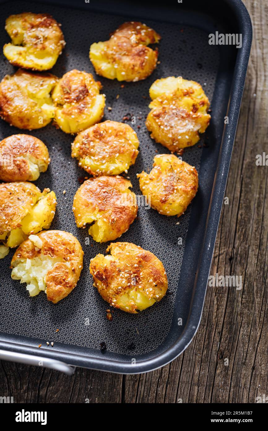 Baked or roast potatoes in metal tray seasoned with rosemary and salt ...