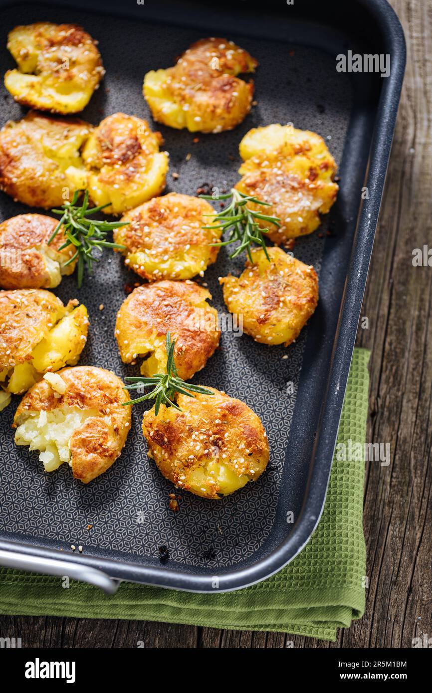 Baked or roast potatoes in metal tray seasoned with rosemary and salt ...