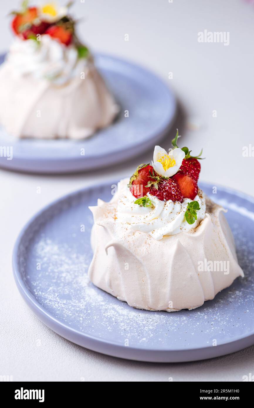 Two small mini pavlova cakes made of meringue decorated with fresh ...