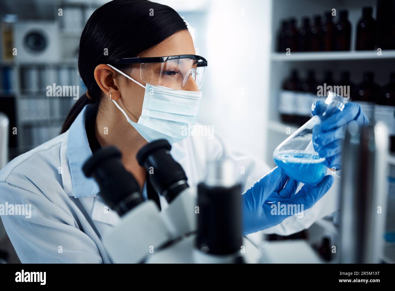 Woman, scientist and analysis of chemical liquid, glass beaker and ...