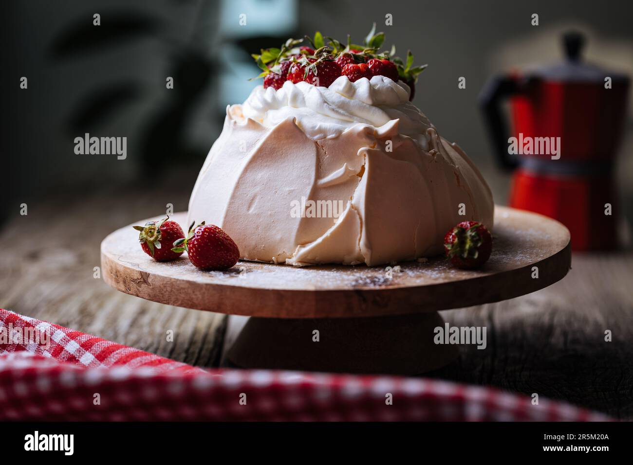 Pavlova cake decorated with strawberries on rustic wooden table surface ...