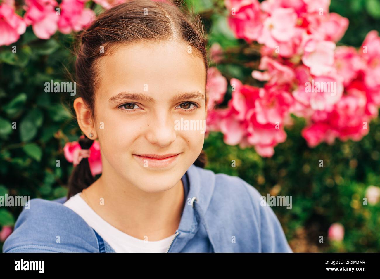 Summer portrait of pretty little girl wearing blue zip hoody, posing in ...