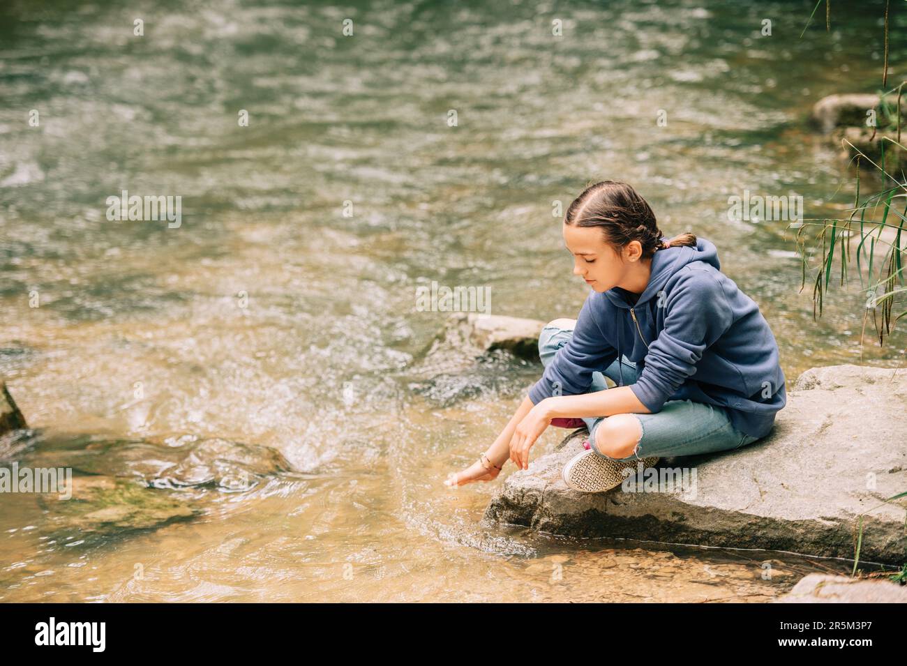Happy young girl resting by river, child and nature, summer camp for ...