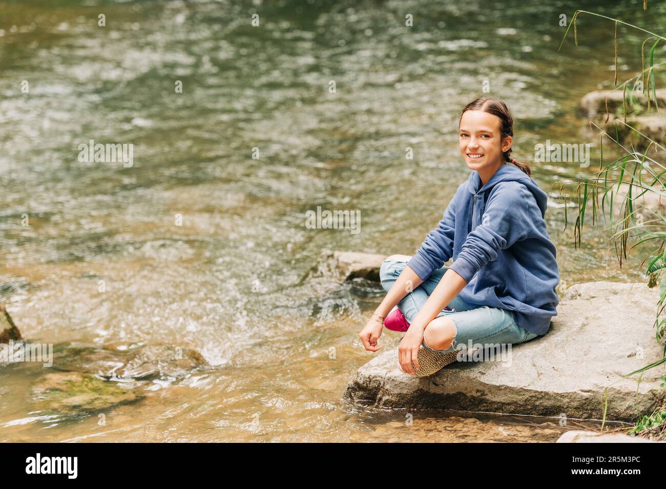 Happy young girl resting by river, child and nature, summer camp for ...
