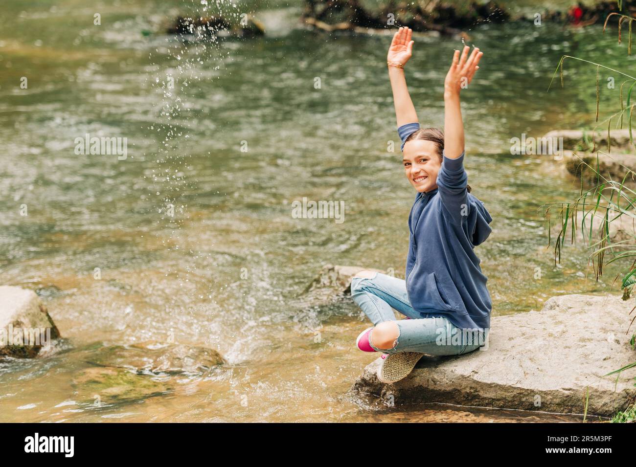 Happy young girl resting by river, child and nature, summer camp for ...