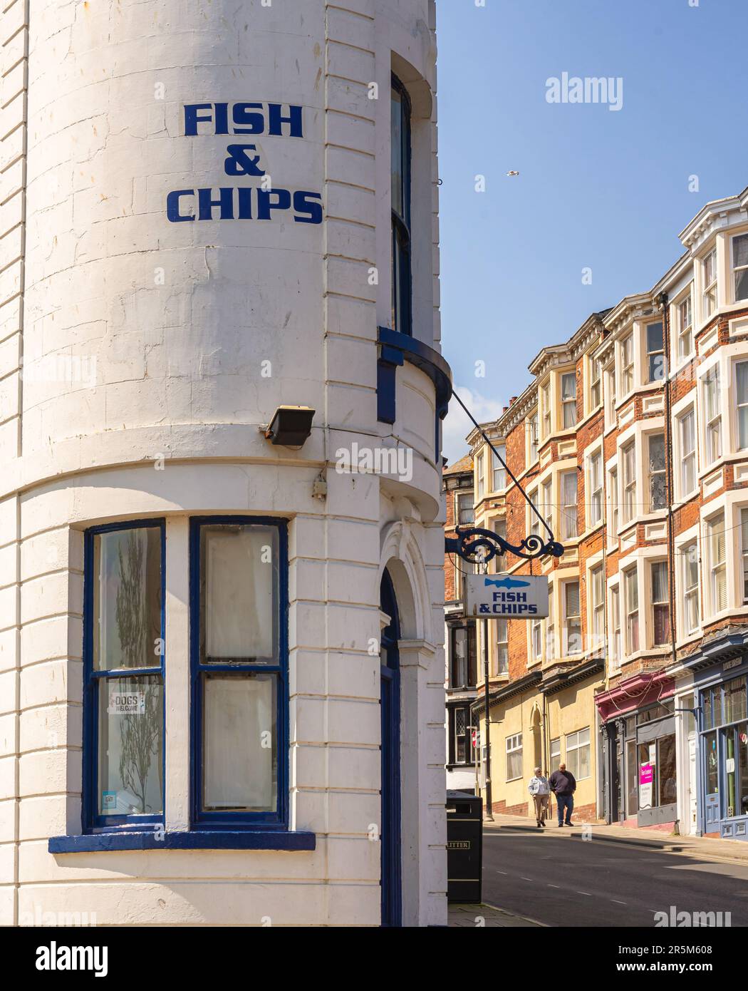 A fish and chip restaurant in a curved building on a sloping street ...