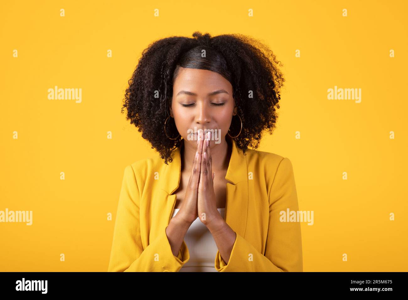 Calm spiritual young black lady praying with closed eyes, peaceful ...