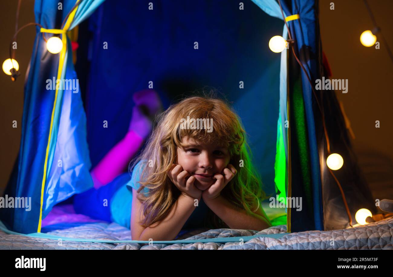 Night kids bedtime. Child lying in kids tent. Little before going to ...